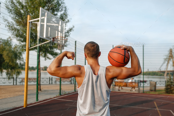 Male basketball player with ball shows his muscles Stock Photo by ...