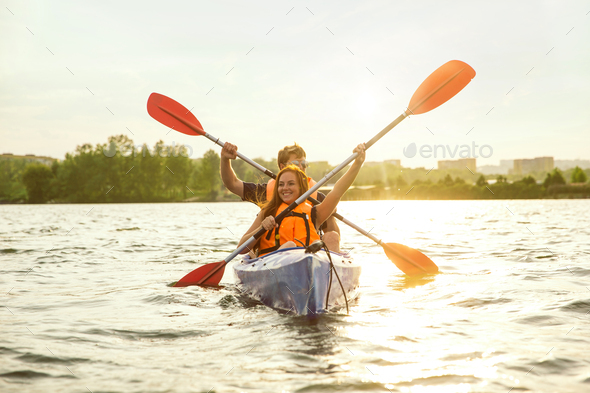 Happy couple kayaking on river with sunset on the background Stock ...