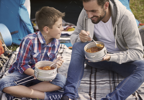 Shared dinner eaten by the father and his son Stock Photo by gpointstudio