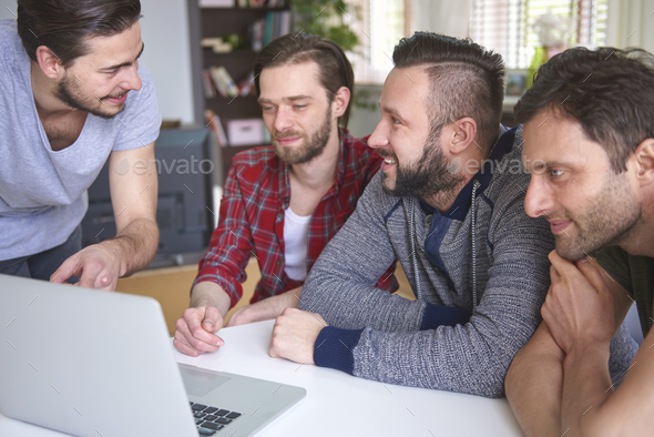 Man standing and explaining his friends how it works Stock Photo by ...