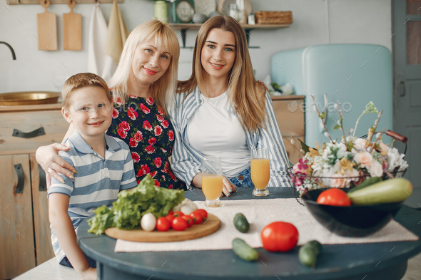 Beautiful big family prepare food in a kitchen Stock Photo by prostooleh