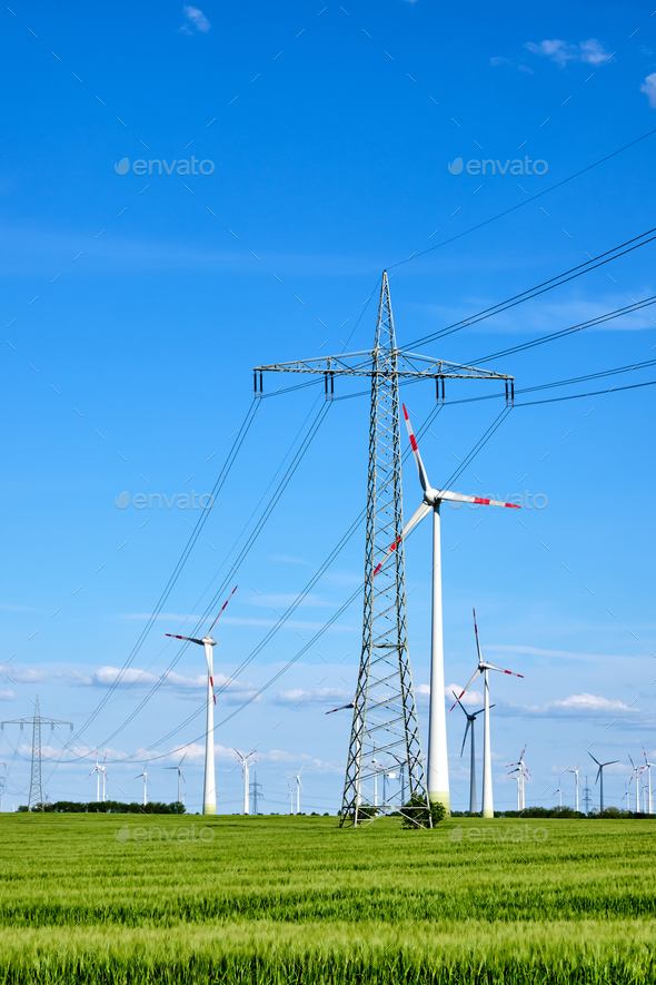 Overhead power lines and wind energy generators Stock Photo by elxeneize