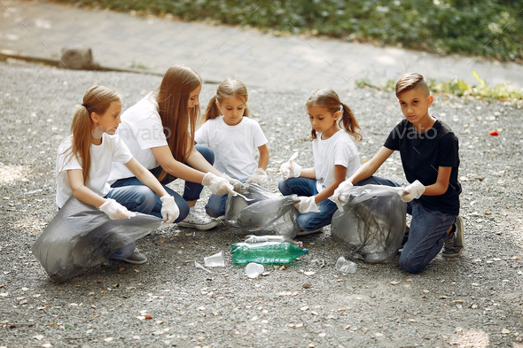 Children collects garbage in garbage bags in park Stock Photo by prostooleh