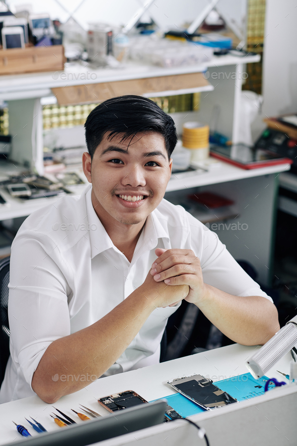 Positive repairman at his desk Stock Photo by DragonImages | PhotoDune
