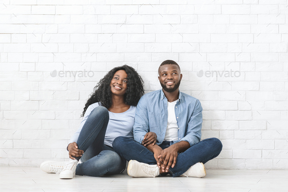 Dreamy black couple sitting on floor, planning interior Stock Photo by ...