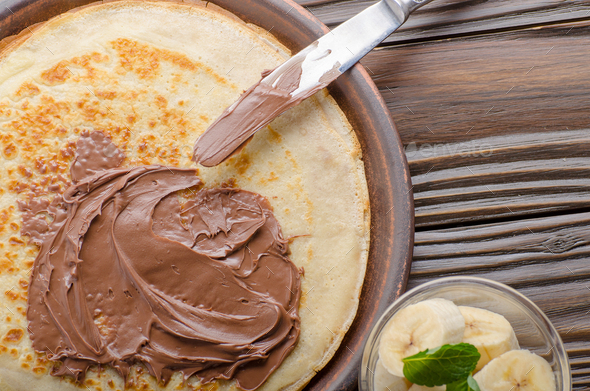 Flat lay French crepes with chocolate sauce and banana in clay b Stock ...