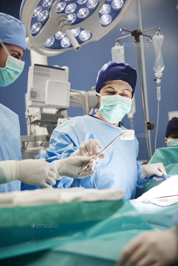 Surgeons passing scissors to each other during an operation Stock Photo ...