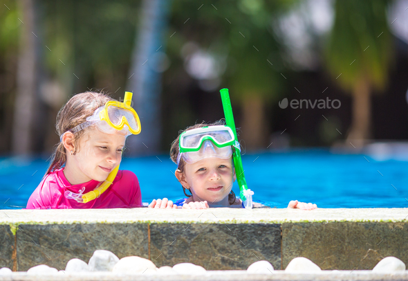 Adorable little girls having fun in outdoor swimming pool on summer ...