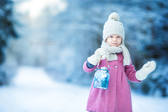 Adorable girl with lamp and candle in winter on Xmas eve outdoors Stock ...