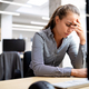 Overworked and frustrated young woman in front of computer in office ...