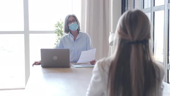 Senior Recruiter Wearing Face Mask Talking To Female Applicant at Job ...