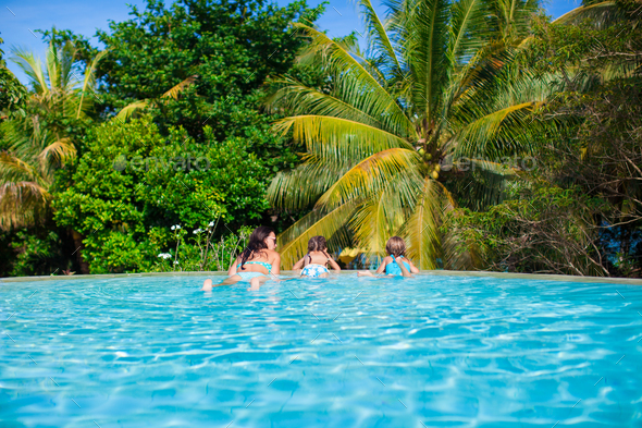 Mother and her kids enjoying the luxury quiet swimming pool Stock Photo ...