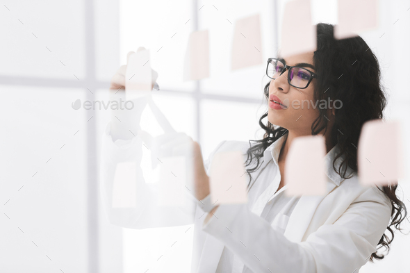 Mexican manager putting sticky notes on window Stock Photo by Prostock ...