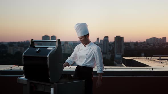 A professional Chef prepares a barbecue on the rooftop of a skyscraper ...