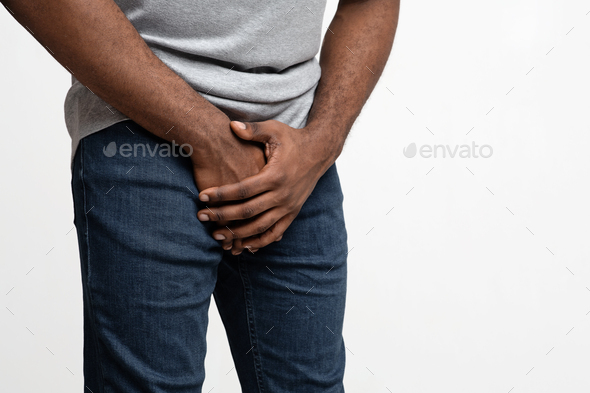 Cropped of black guy holding his groin Stock Photo by Prostock-studio