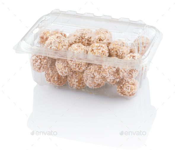rounds candy with coconut shavings in a plastic container isolated on ...
