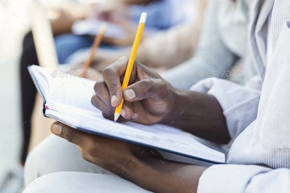 Cropped of afro student taking notes, using notepad and pencil Stock ...