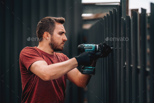 Construction worker using screwdriver for fastening and drilling screws ...