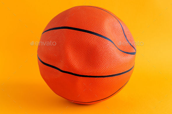 Deflated Basketball Ball on Yellow Background Stock Photo by stevanovicigor