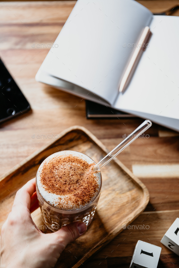 Cup of latte served with glass tube on a wooden work desk Stock Photo ...