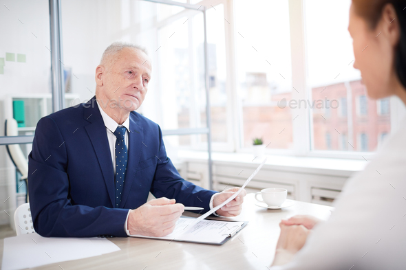 Senior Man Interviewing Job Candidate Stock Photo by seventyfourimages