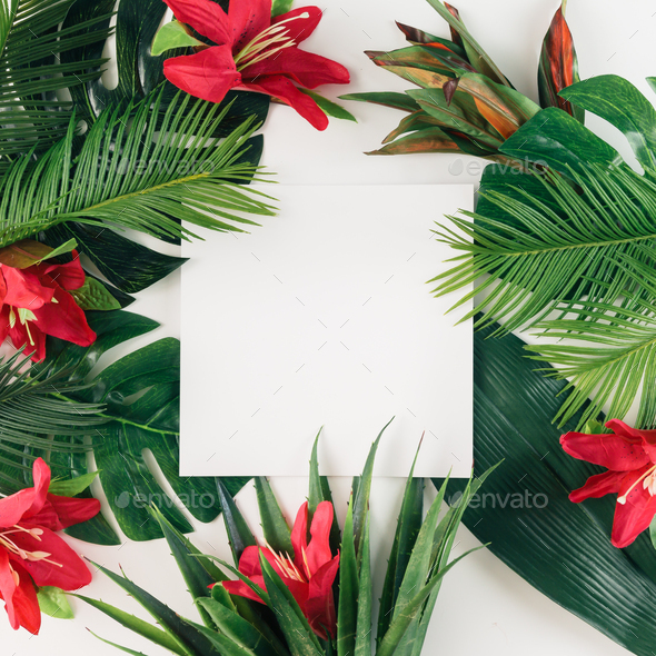 Creative layout made of tropical palm leaves and colorful flowers ...