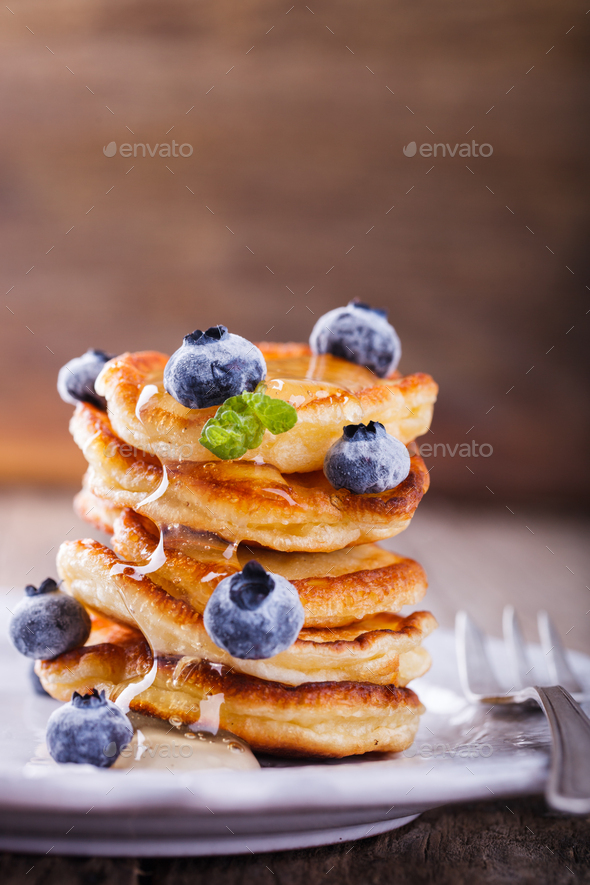 Pancake folded stack of with liquid honey and fresh blueberries Stock ...