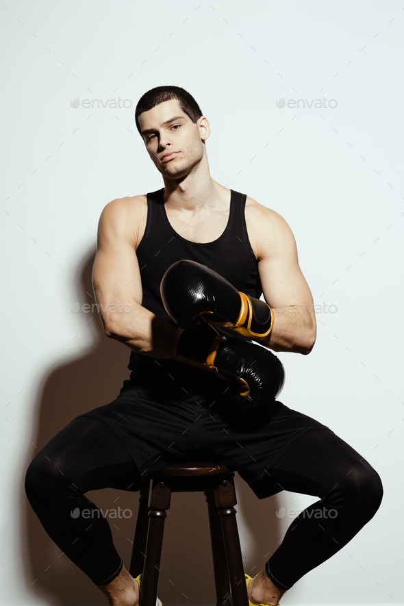 Boxer putting on his boxing gloves while resting on the chair Stock ...