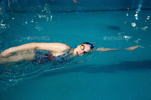 Female swimmer swimming on her back in pool Stock Photo by NomadSoul1