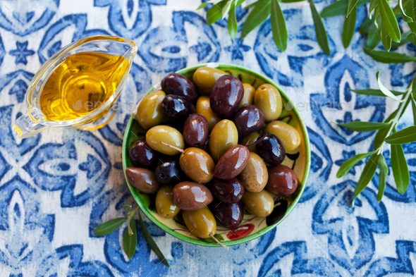 Assortment of Fresh Olives on a Plate with Olive Tree Brunches. Blue ...