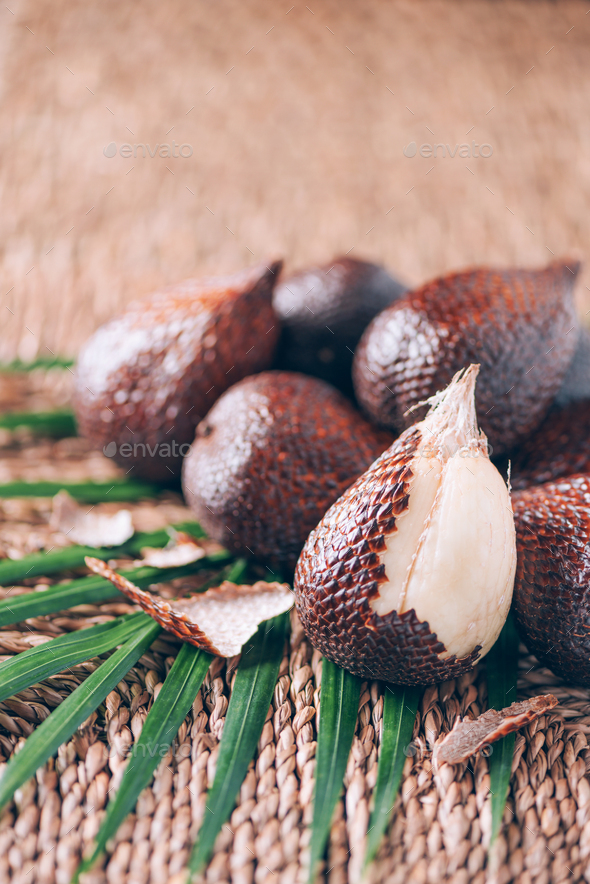 Red Salacca. Salak, snake fruits with palm leaves on rattan background ...