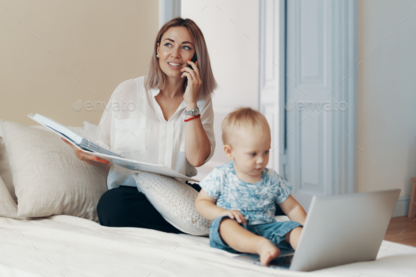 Modern woman working with child. Multi-tasking, freelance and ...
