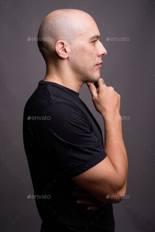 Portrait of handsome bald man against gray background Stock Photo by ...