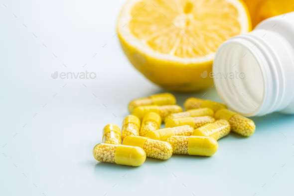 Vitamin capsules. Vitamin C pills, lemon fruit and pill bottle. Stock ...