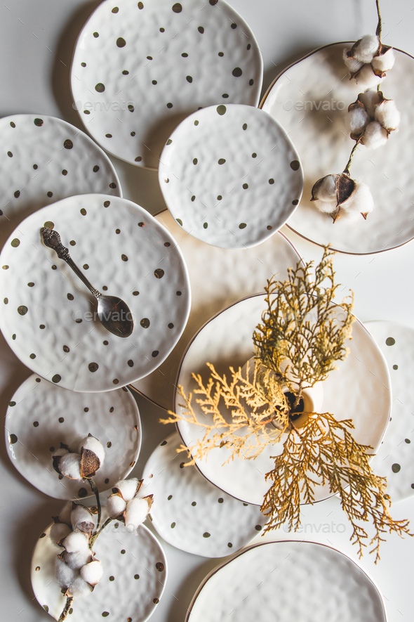 Beautiful plates on a white background with cotton. Beautiful layout ...