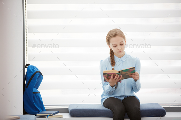 Smart Girl Reading Book in School Stock Photo by seventyfourimages