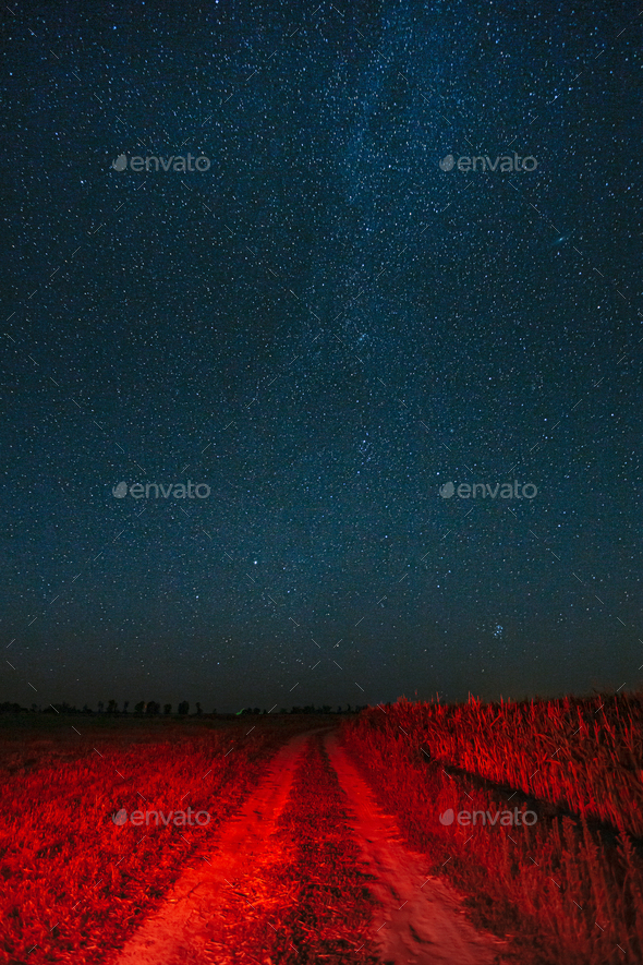 Night Starry Sky With Glowing Stars Above Country Road Is Lit In Red ...
