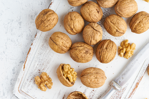Top view walnut in endocarp, bowl with drupe in shell on white wooden ...