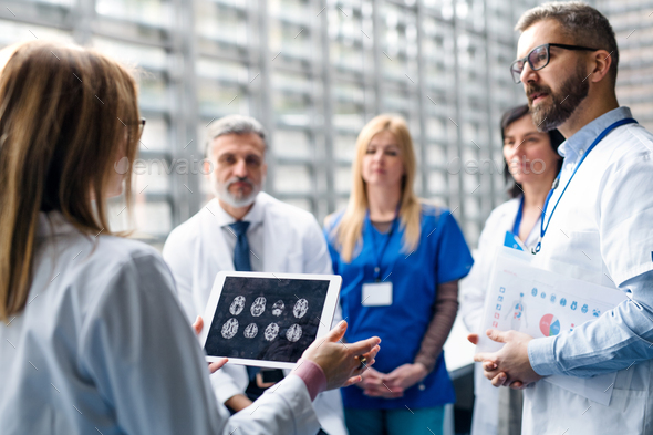 Group of doctors with tablet on medical conference, discussing issues ...