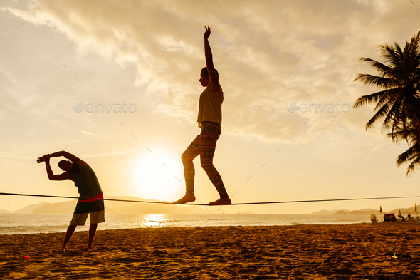 teenagers balance on slackline silhouette Stock Photo by avanti_photo