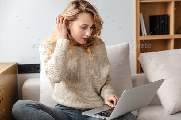 Concentrated gorgeous young woman using laptop computer. Stock Photo by ...