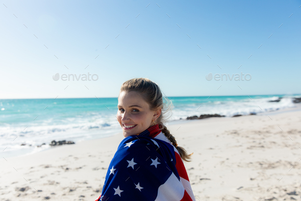 Woman with american flag at the beach Stock Photo by Wavebreakmedia