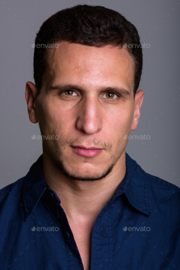 Face of young muscular Persian man against gray background Stock Photo ...