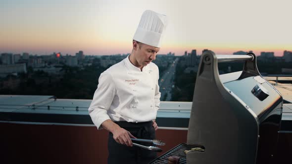 A professional Chef prepares a barbecue on the rooftop of a skyscraper ...