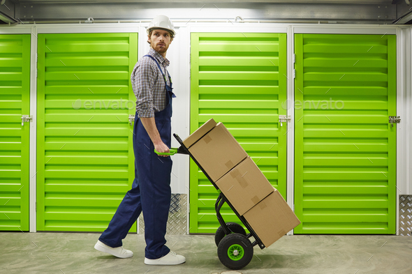 Worker carrying cart in warehouse Stock Photo by AnnaStills | PhotoDune