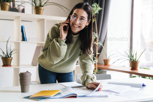 Optimistic young girl student studying talking Stock Photo by vadymvdrobot