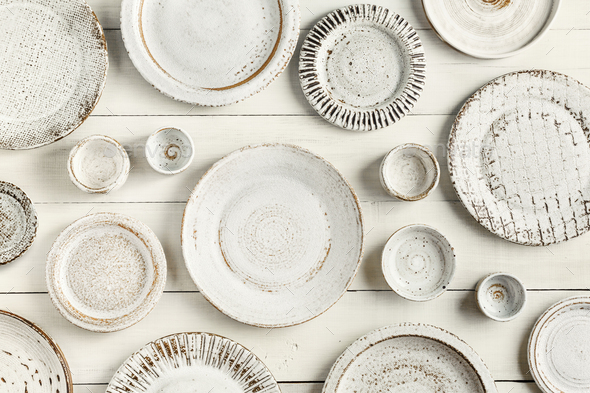 Ceramic plates of different sizes on a white wooden background Stock ...
