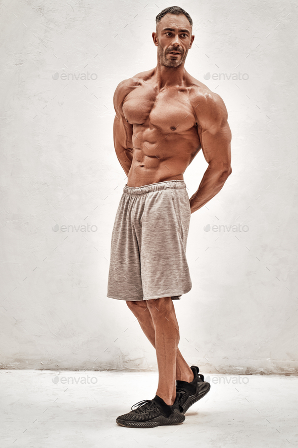 Embossed fitness couch showing his muscles looking powerful Stock Photo ...