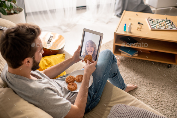 Pretending to eat cookie through tablet screen Stock Photo by Pressmaster