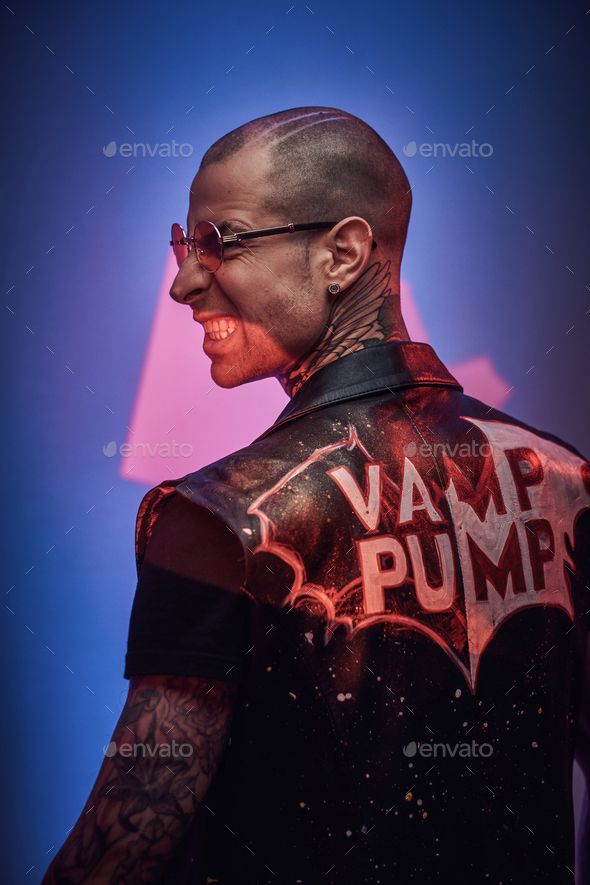 Fashionable tattooed male model posing in a studio Stock Photo by fxquadro